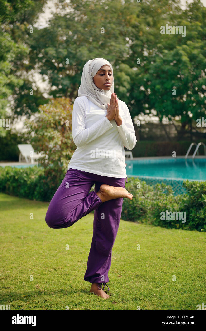 Muslim woman doing yoga by the poolside Stock Photo - Alamy