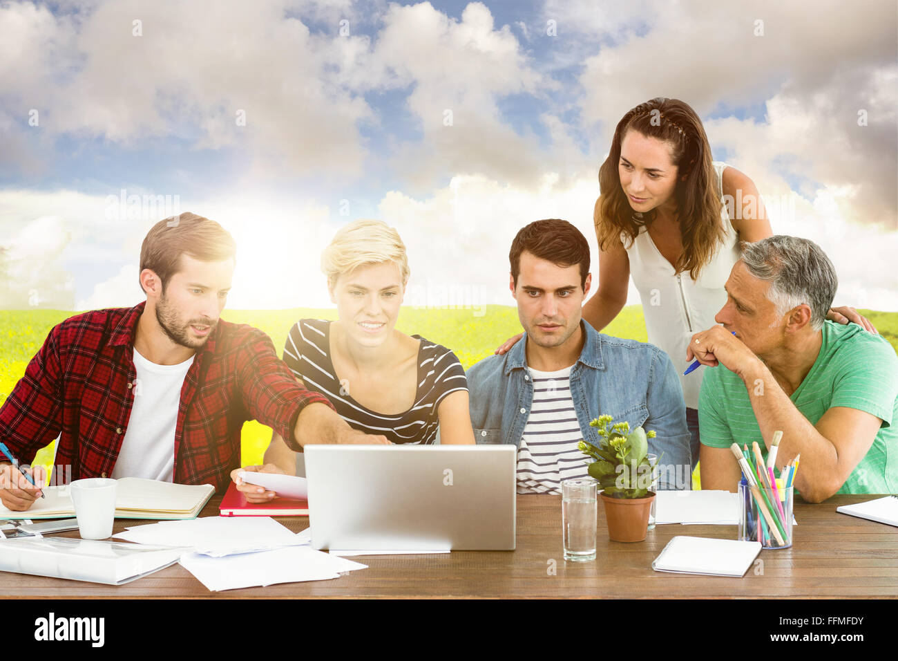 Composite image of teamwork using laptop together Stock Photo - Alamy