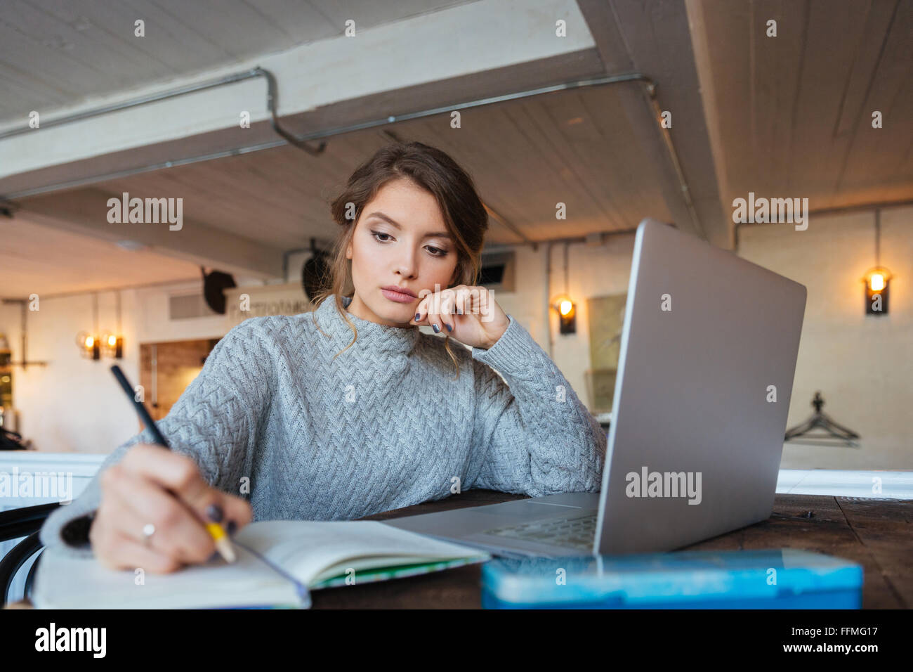 Woman working with laptop computer and notepad in cafe Stock Photo - Alamy