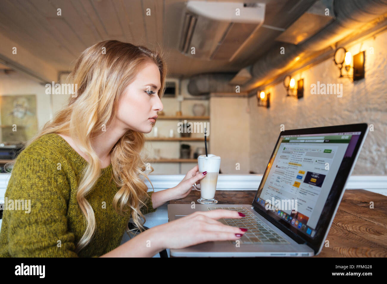 Blonde woman using laptop computer in cafe Stock Photo - Alamy