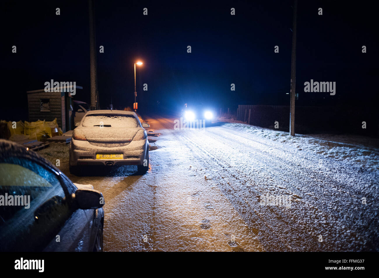 Cars parked on a snowy road at night in Leslie in Aberdeenshire ...