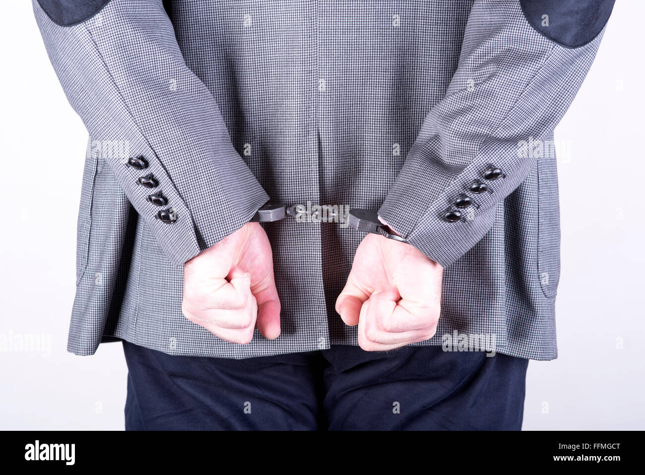 a picture of a businessman locked in handcuffs Stock Photo - Alamy
