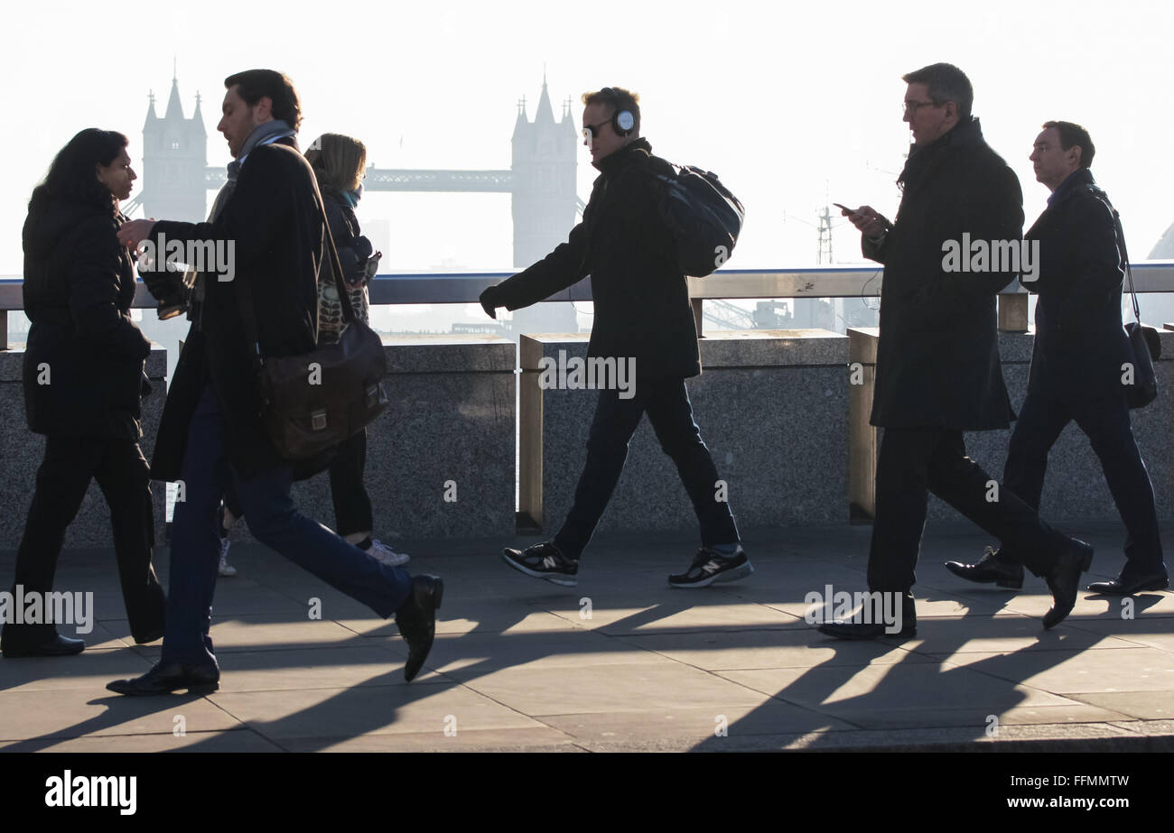 Office workers crossing London Bridge on a cold morning, London ...