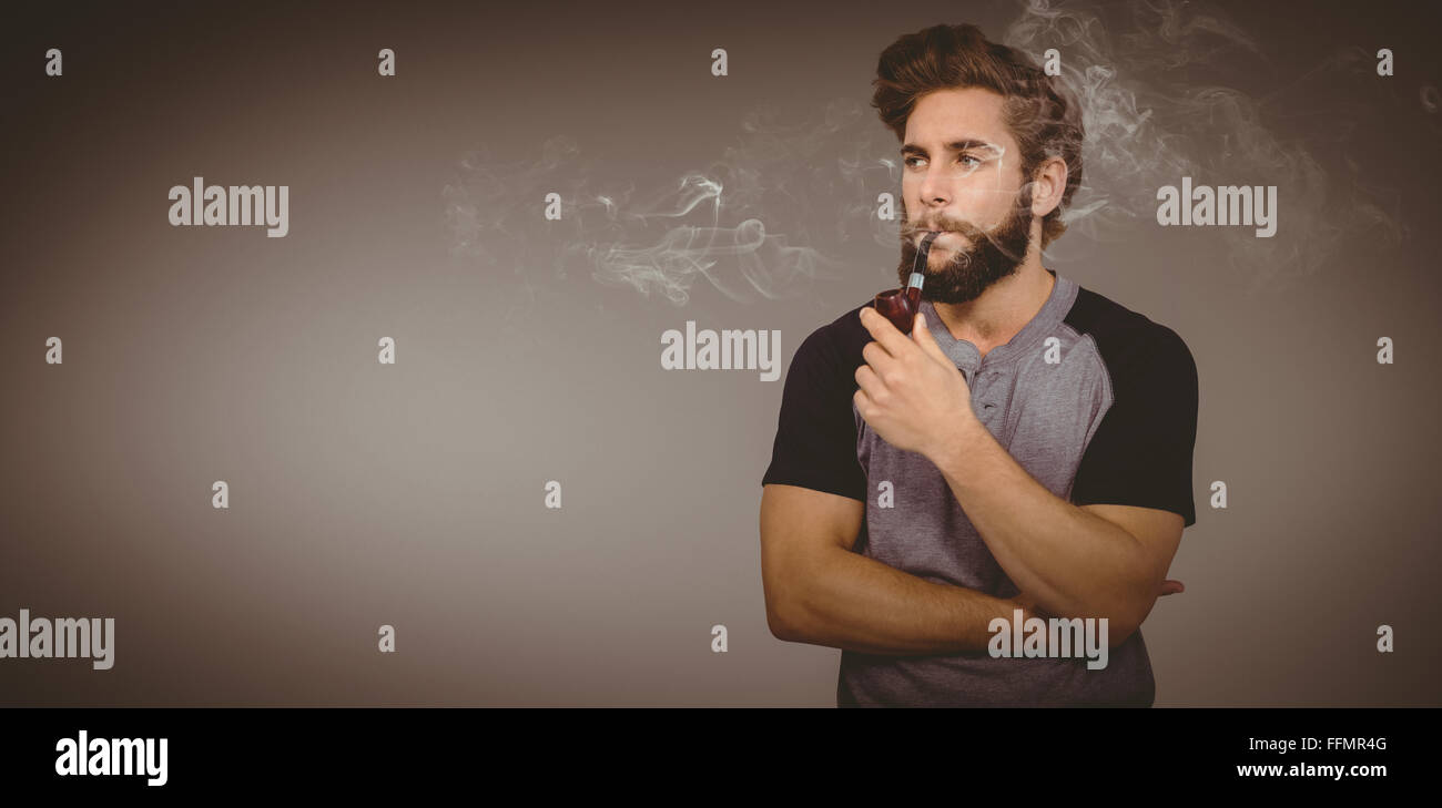 Composite image of confident hipster smoking pipe Stock Photo - Alamy