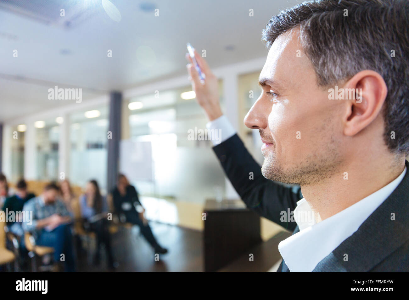 Closeup of handsome serious speaker standing with raised hand on ...