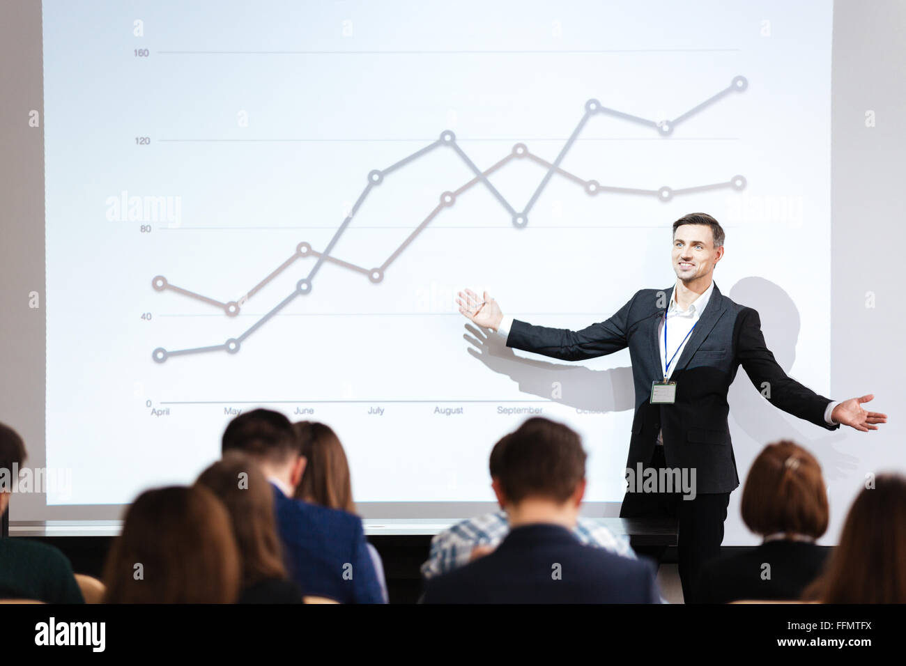 Smiling charismatic speaker giving public presentation in conference ...