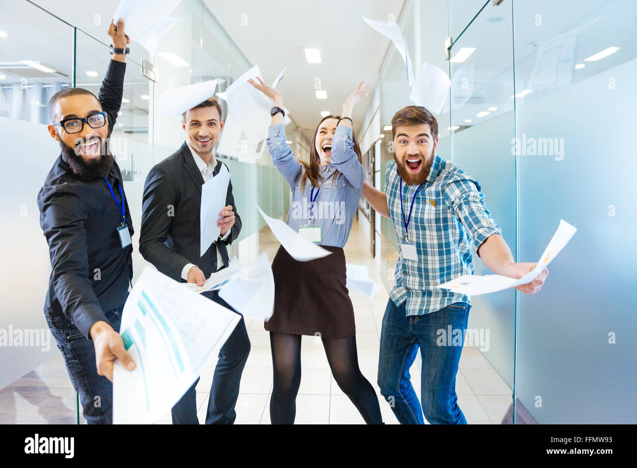 Group of joyful excited business people throwing papers and having fun ...