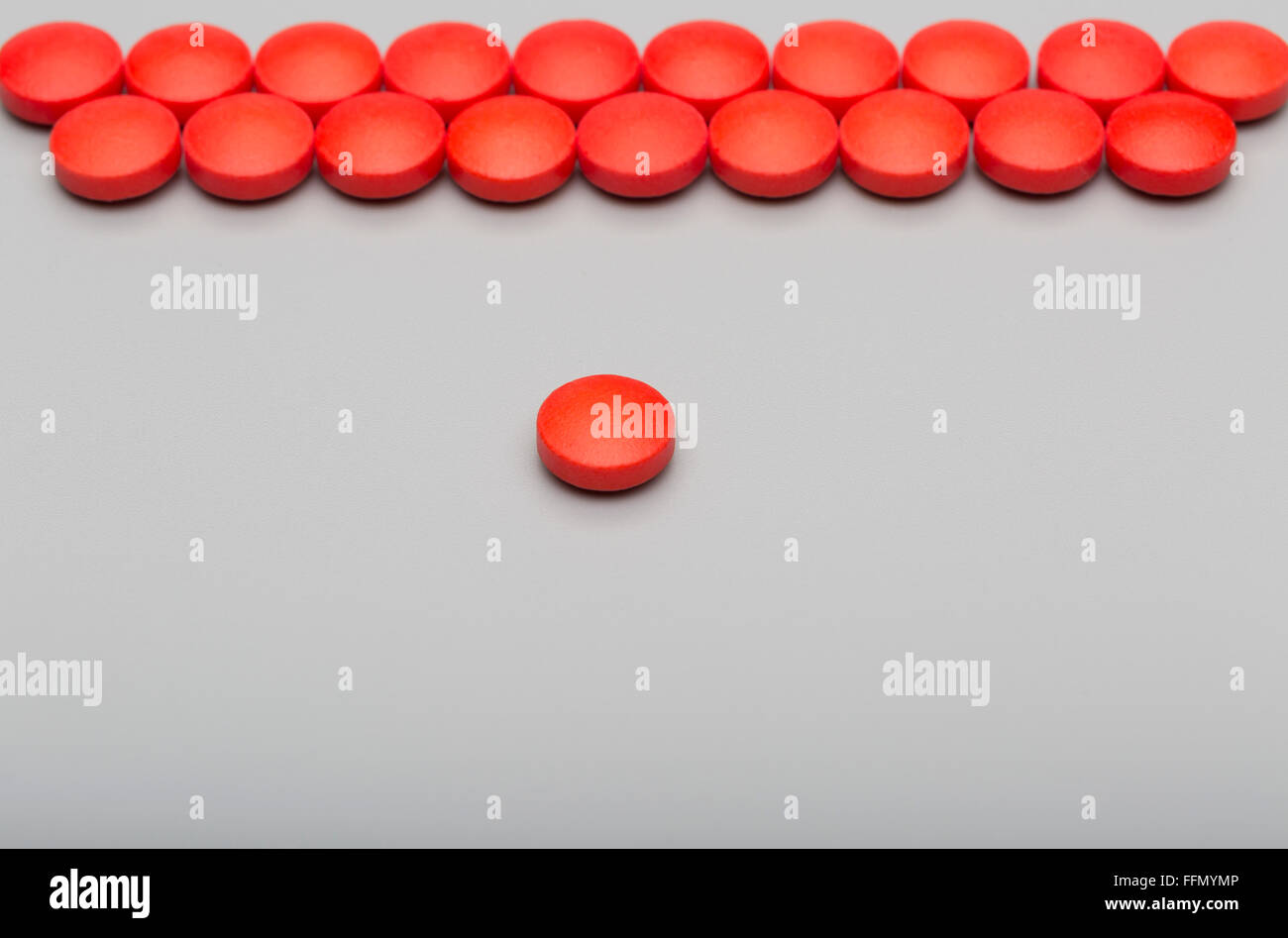 Red round pills on the grey background Stock Photo - Alamy