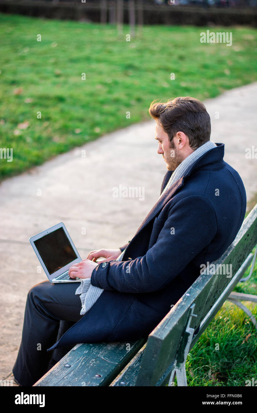 Businessman sitting on bench park working on laptop hi-res stock ...