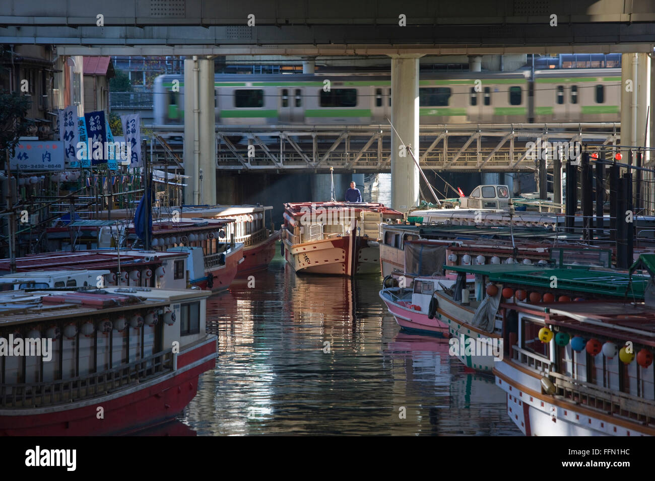 With a city commuter train rushing past in the background a boat ...