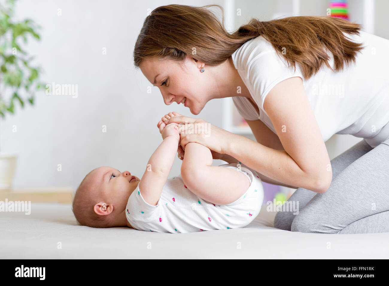 joyful mother playing and doing gymnastics her baby infant Stock Photo ...