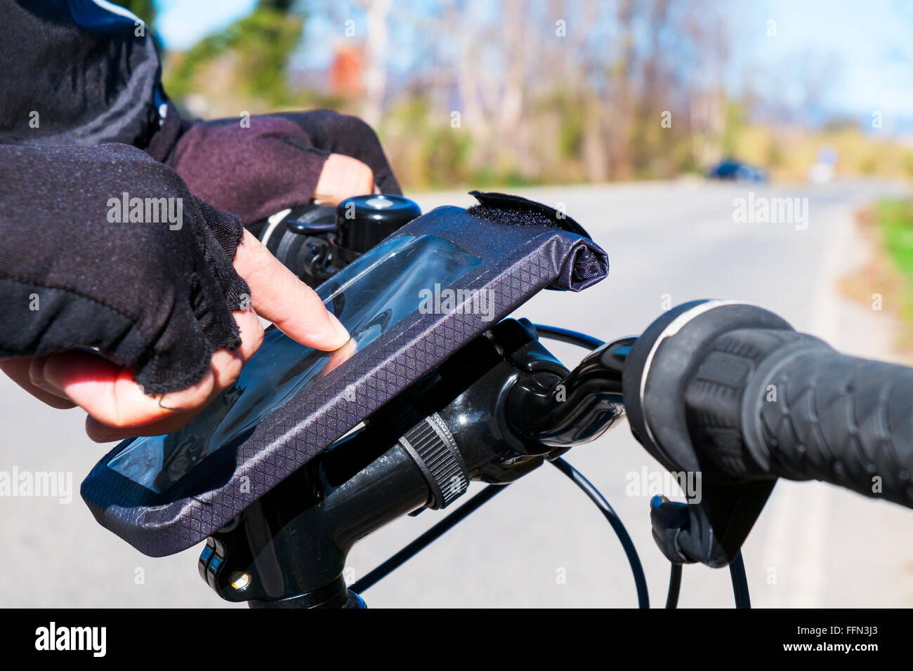 closeup of a young man using a smartphone mounted in the handlebar of a ...