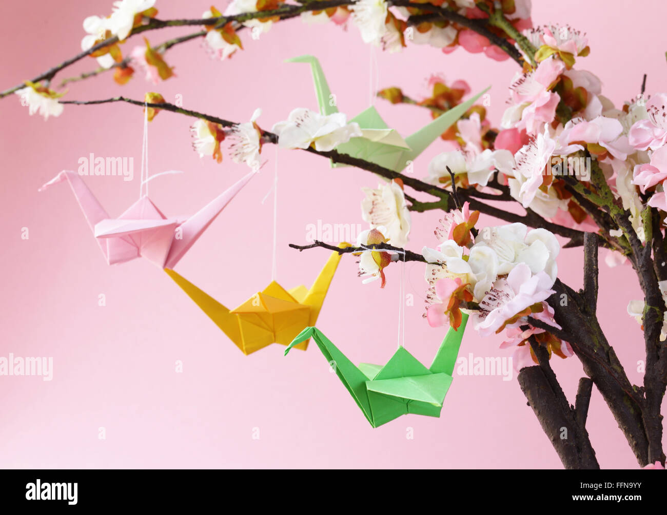 colorful paper origami birds on flowering branches of cherry (sakura ...