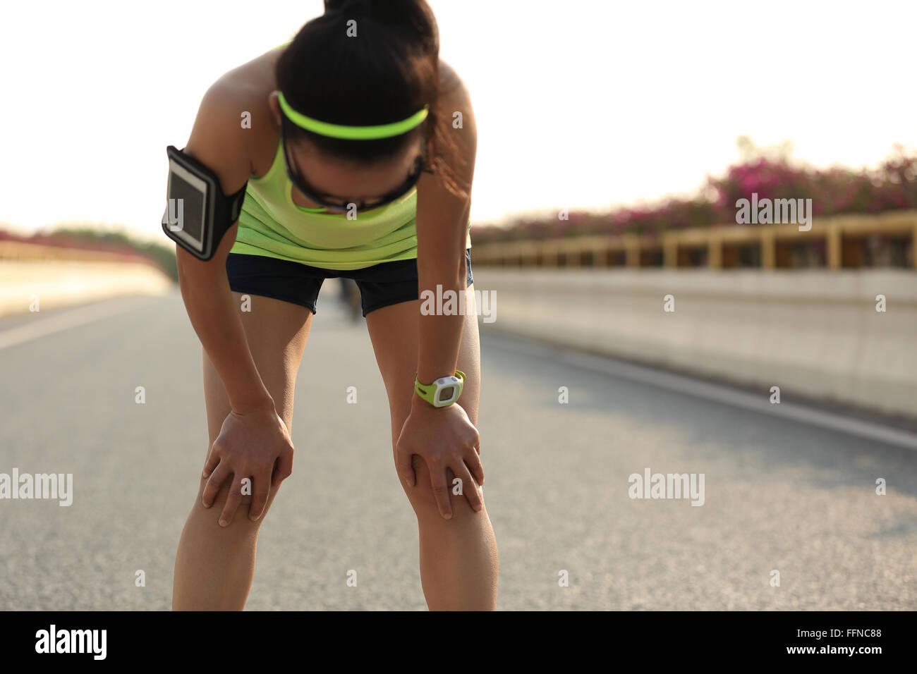 tired woman runner taking a rest after running hard on city road Stock ...