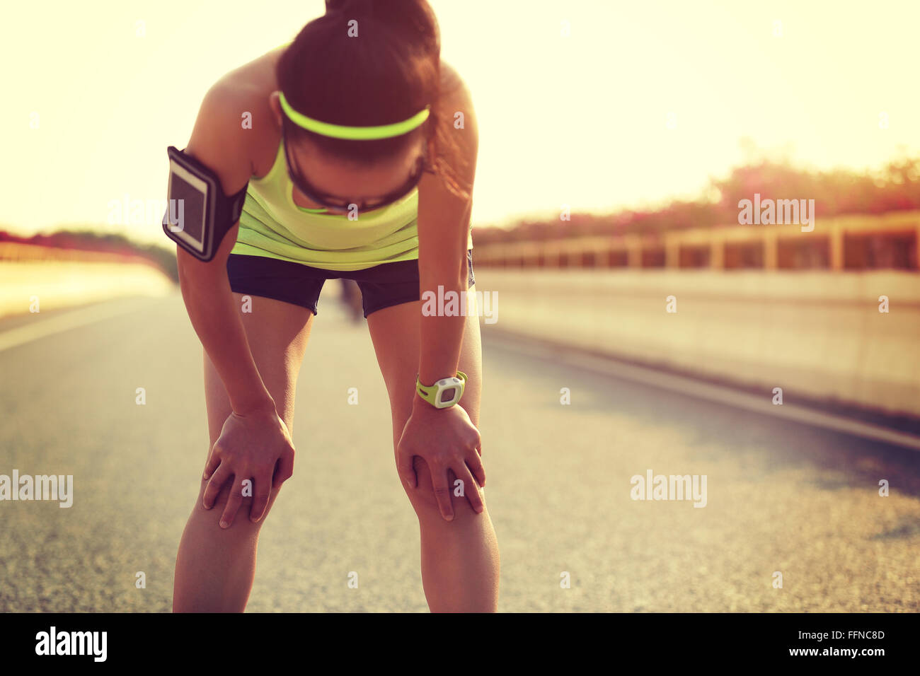 tired woman runner taking a rest after running hard on city road Stock ...