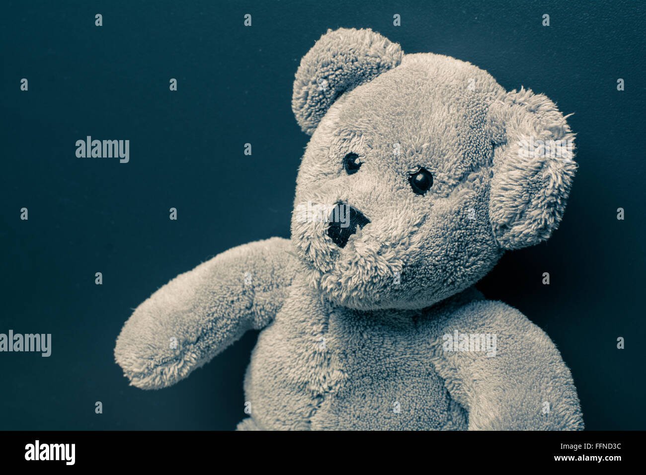 Lonely teddy bear on a dark background looking sad Stock Photo - Alamy