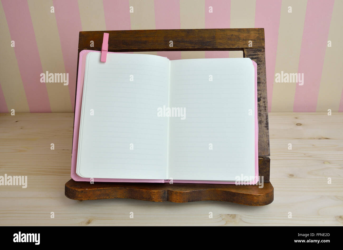 Blank cook book on wooden book holder with pink-yellow kitchen wall ...