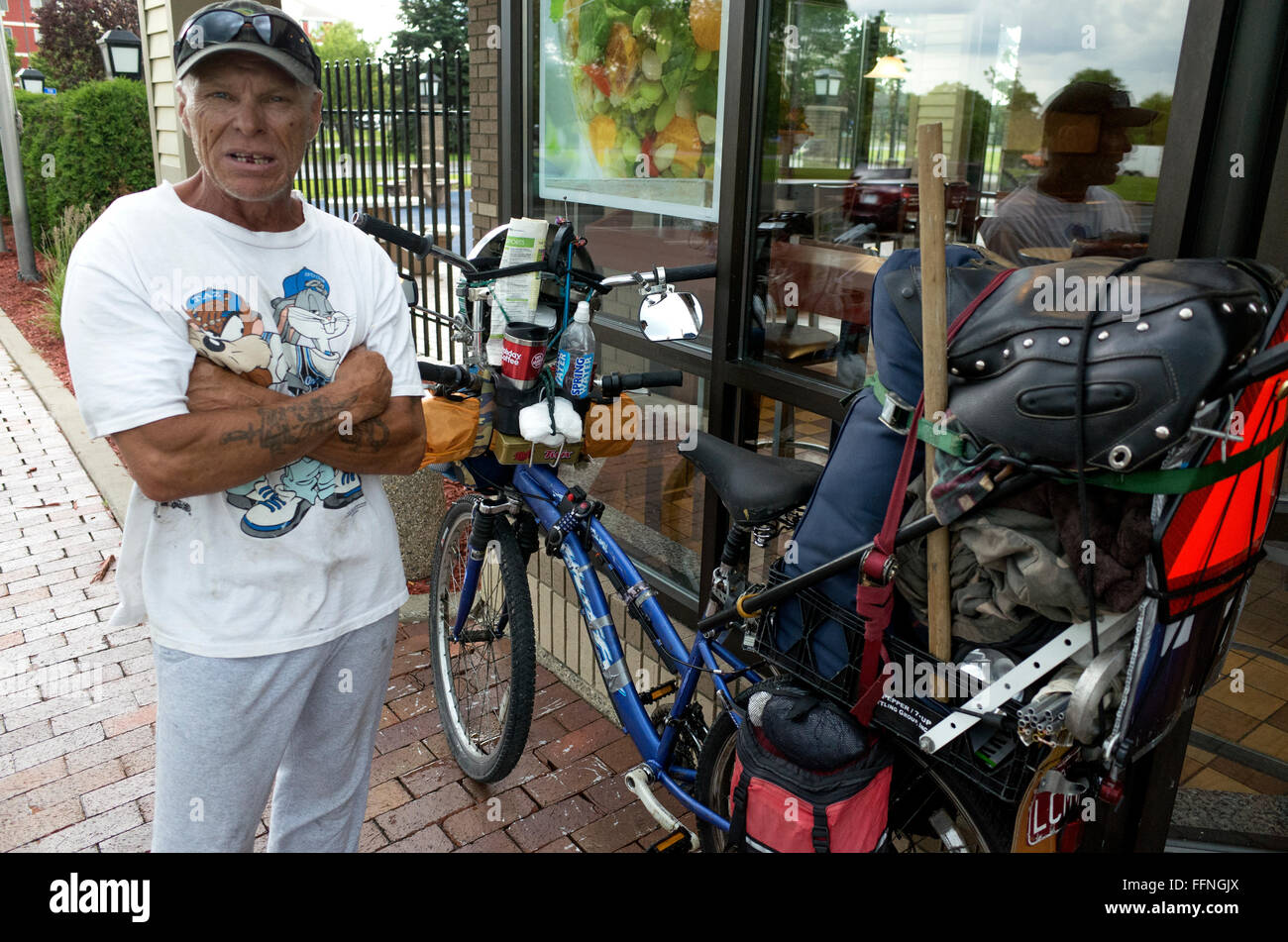 Cross country cyclist taking a lunch break by his fully loaded bicycle ...