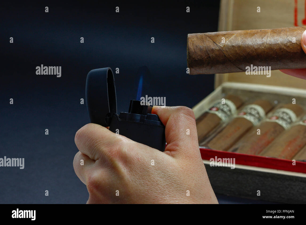 Man who lights his cigar with lighter Stock Photo - Alamy