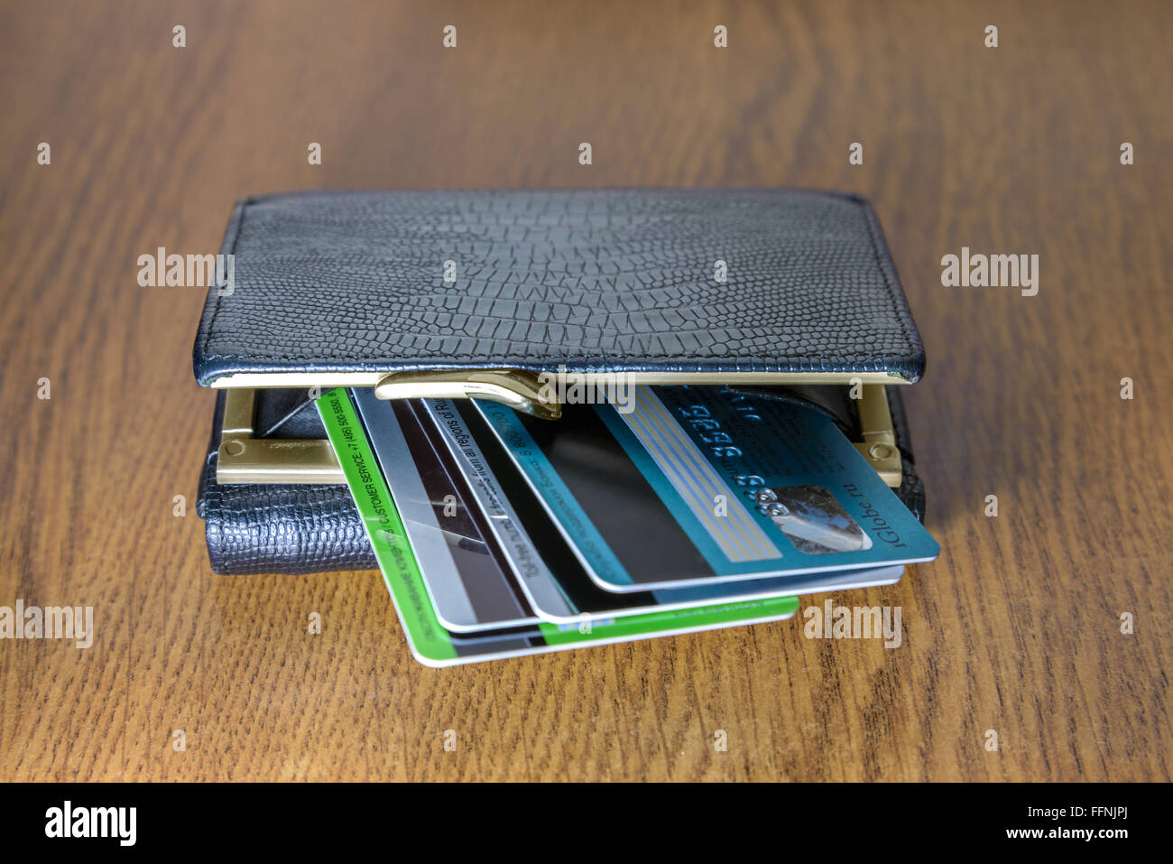 Wallet with credit cards lying on a wooden table Stock Photo - Alamy