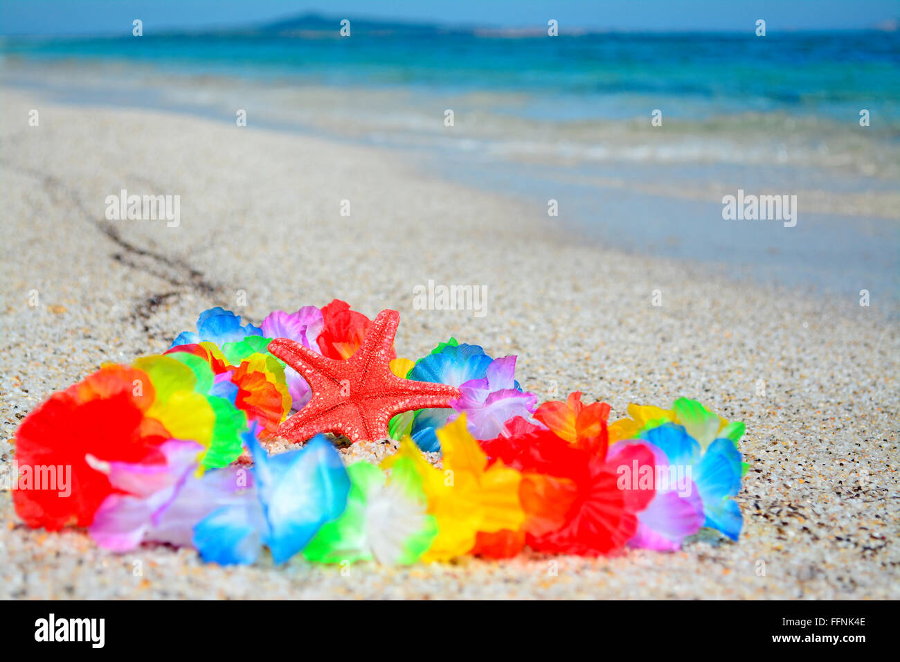 hawaiian necklace and red starfish by a tropical shore Stock Photo - Alamy