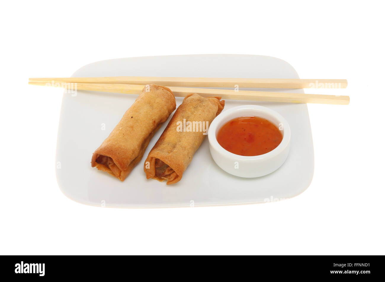 Spring rolls on a plate with a dipping sauce and chopsticks isolated ...