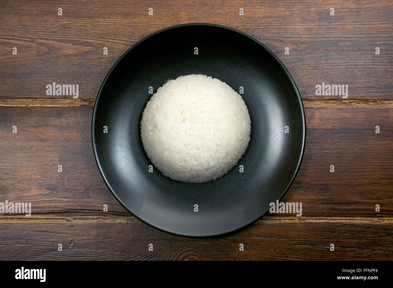 Portion of rice on the black plate top view Stock Photo - Alamy