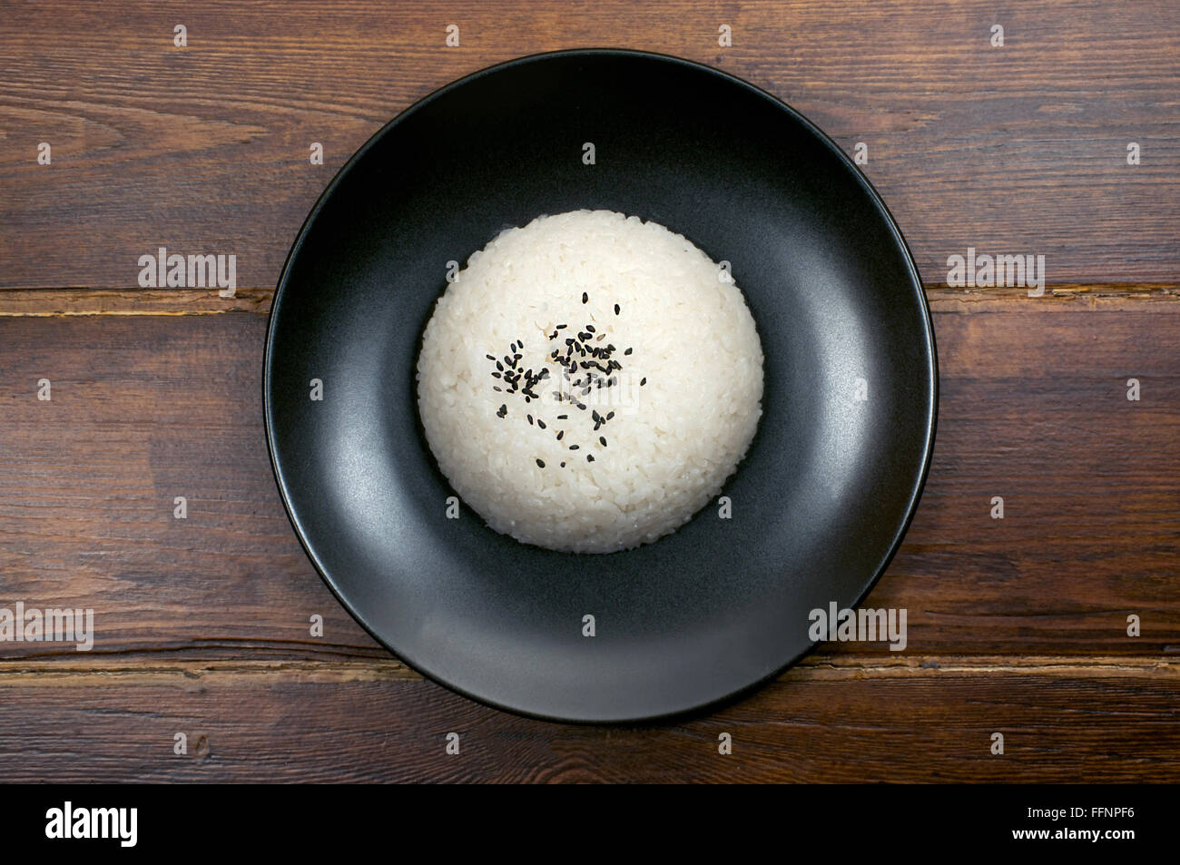 Portion of rice on the black plate top view with sesame Stock Photo - Alamy