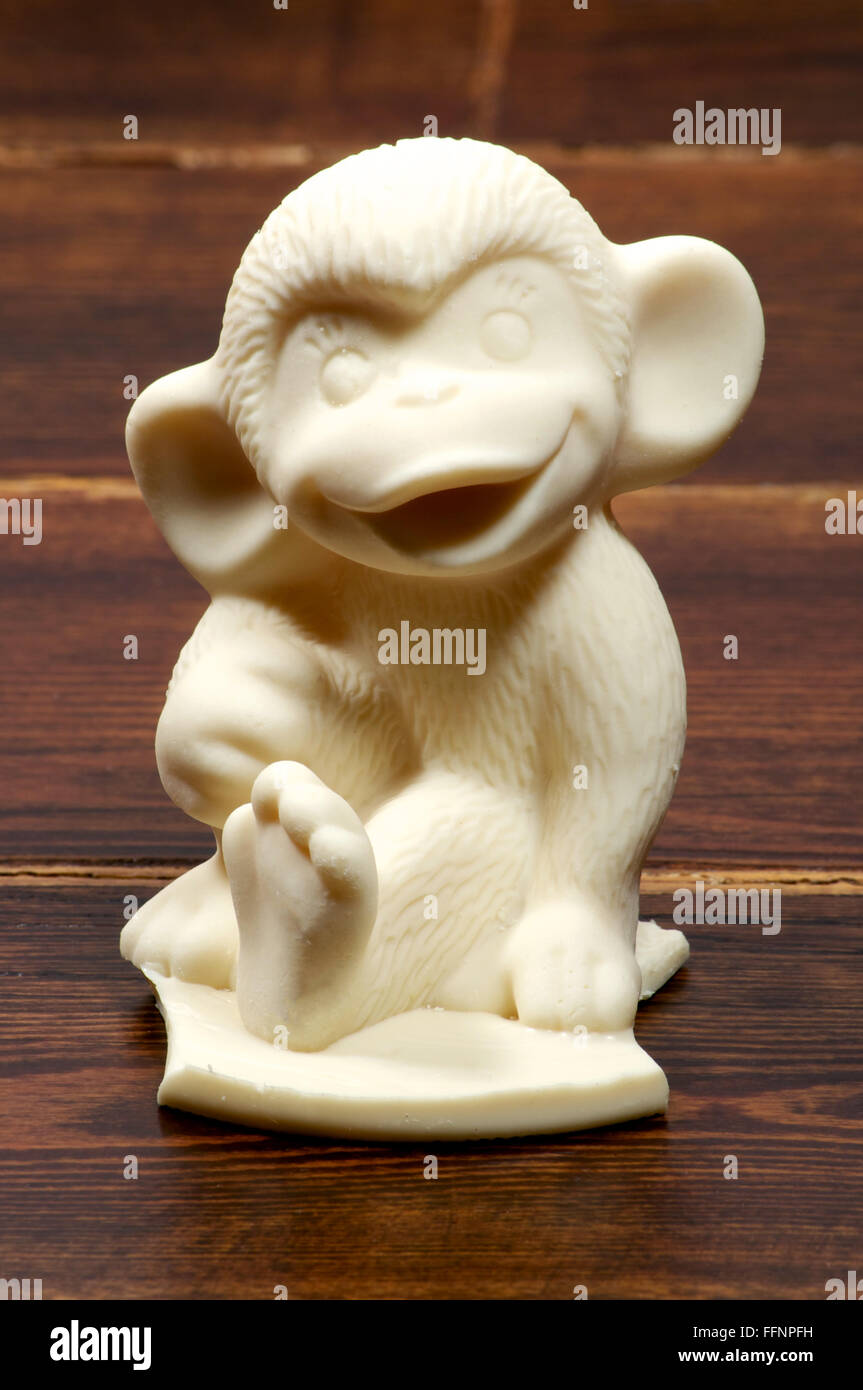 White chocolate monkey over wooden background close up Stock Photo - Alamy