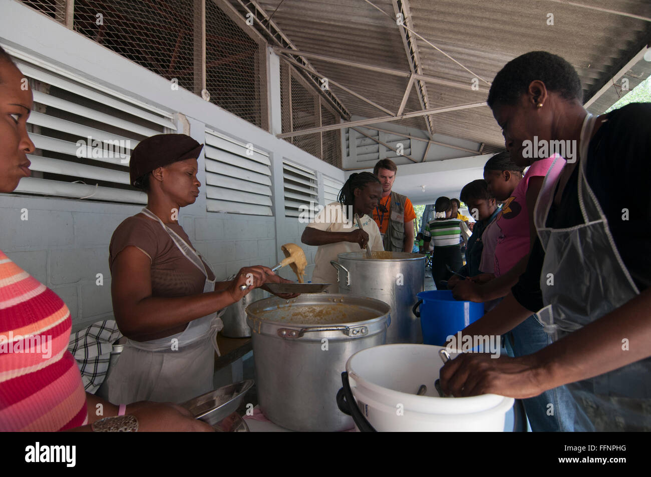 A WFP staff member supervise local people cooking in a kitchen set up ...