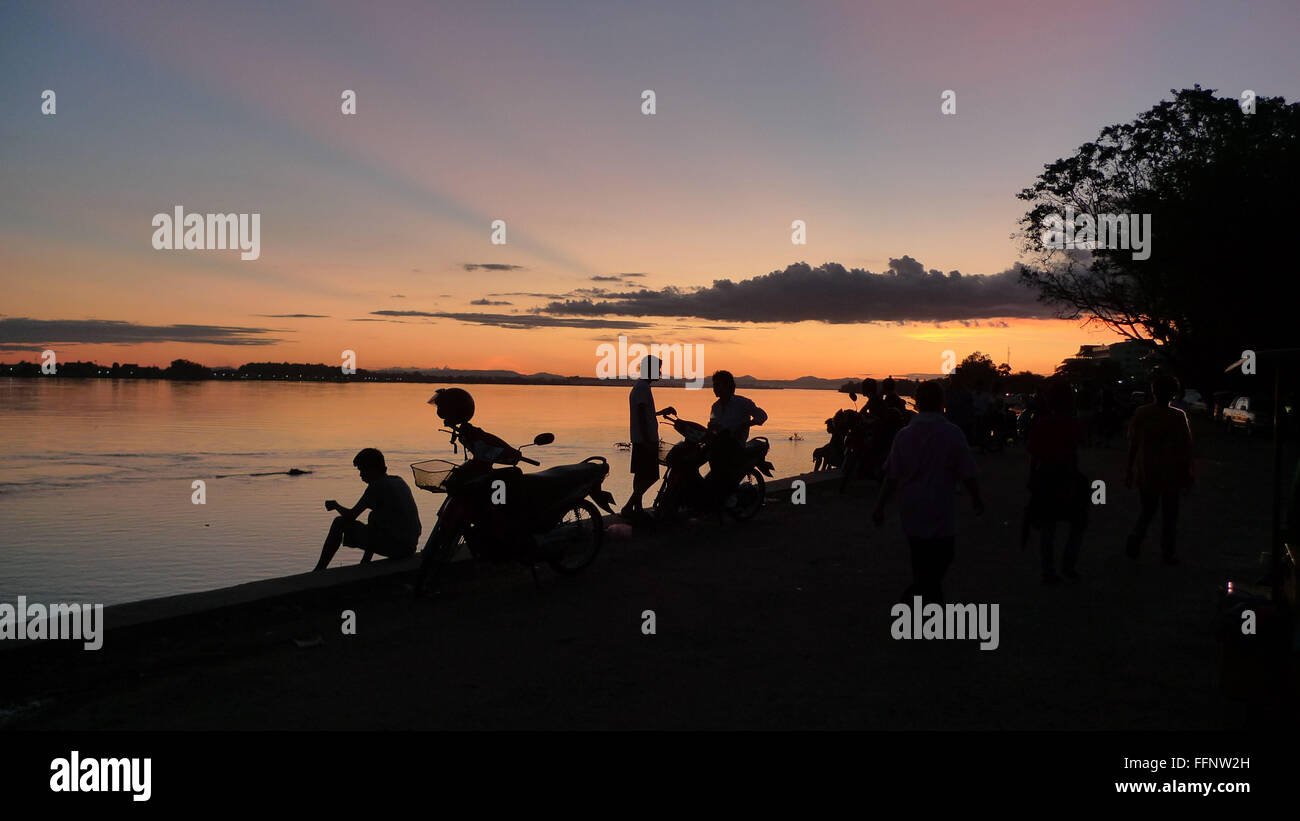 Scene with silhouettes along Mekong River at sunset in Vientiane, Laos ...