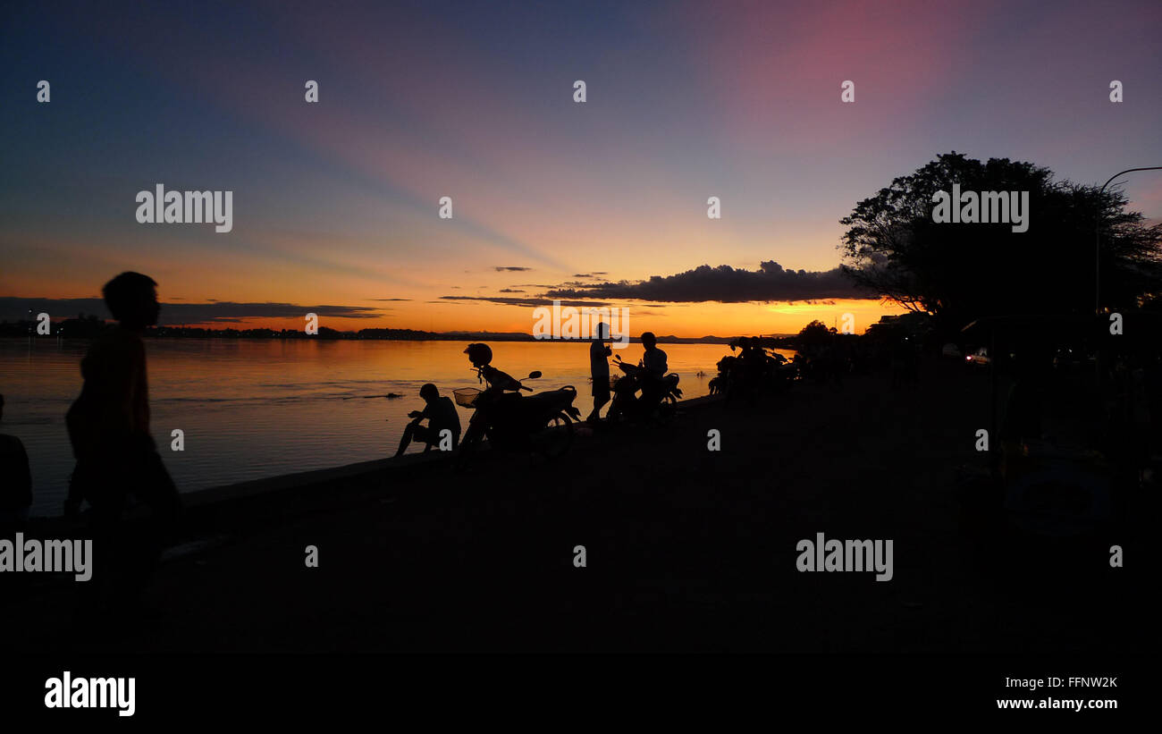 Scene with silhouettes along Mekong River at sunset in Vientiane, Laos ...
