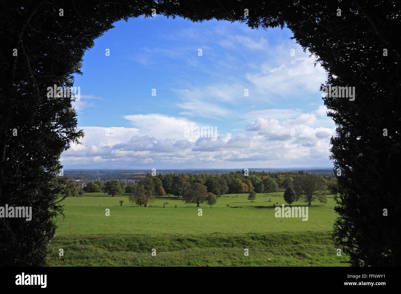 View of the Welsh countryside through an archway trimmed into hedge ...