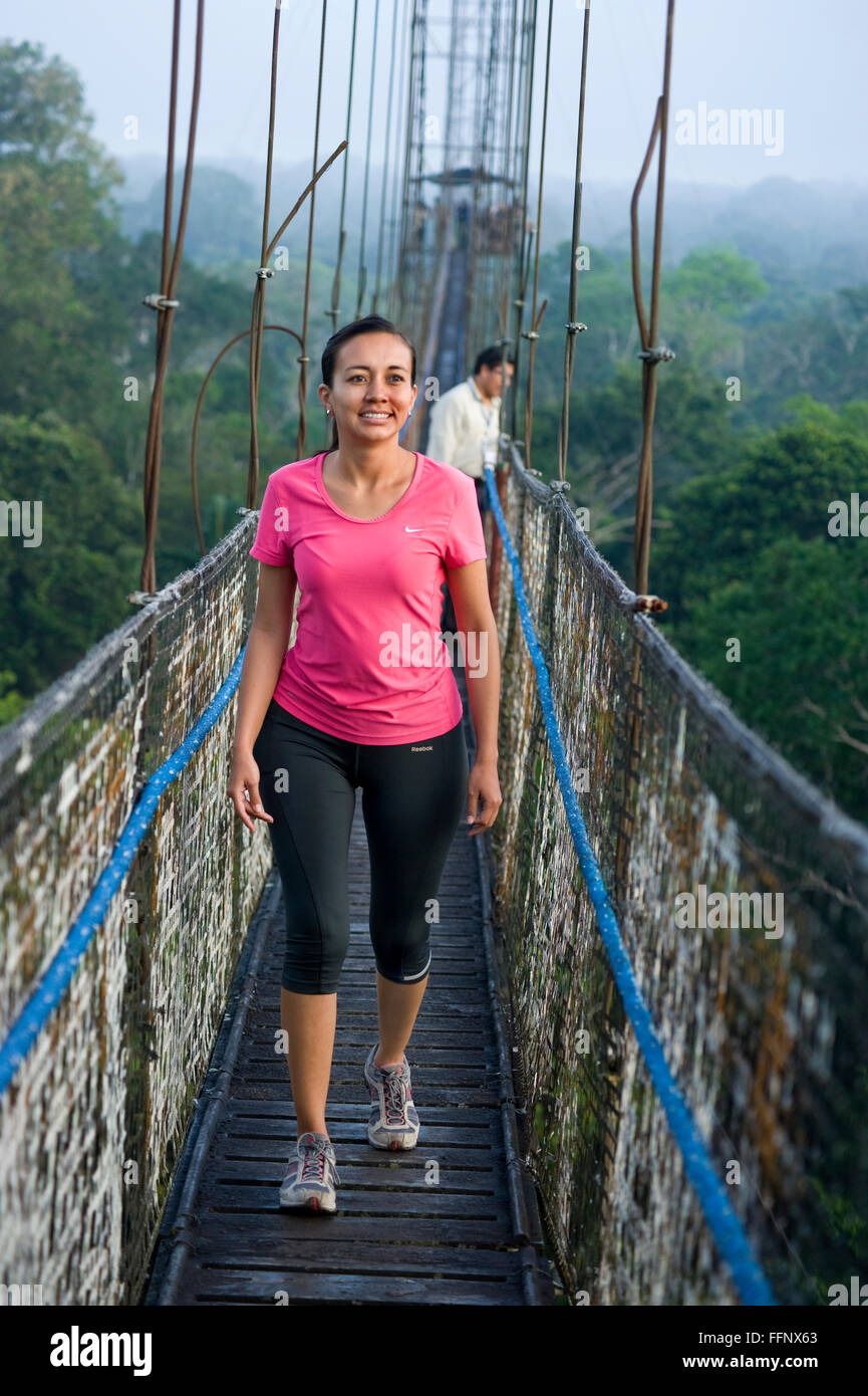 Visitors crossing crossing canopy bridge over Amazon Rani Forest in ...