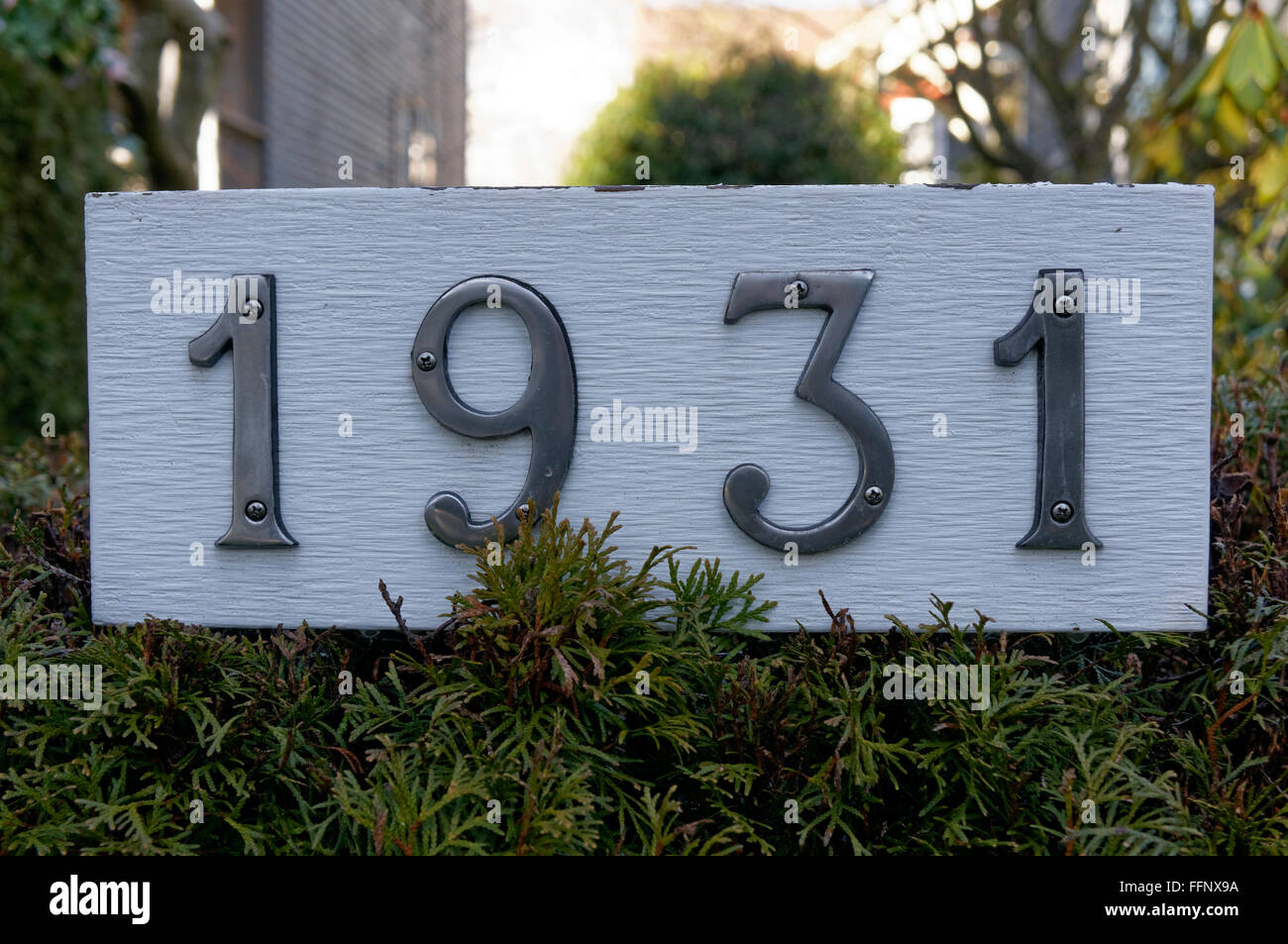 1931 metal house number on a white wooden background Stock Photo - Alamy
