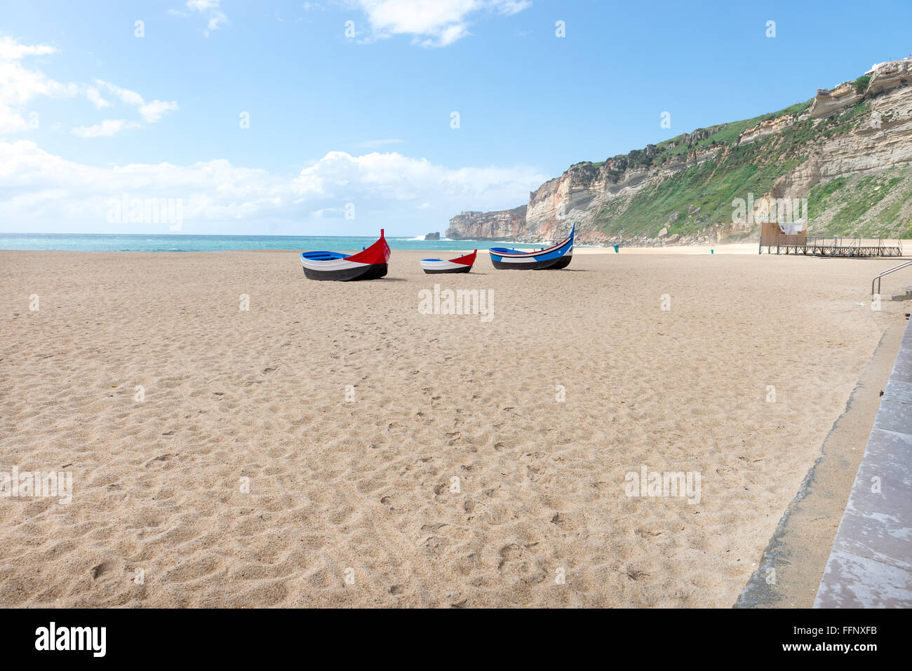Main beach in Nazare with Traditional colorful boat on the sand ...