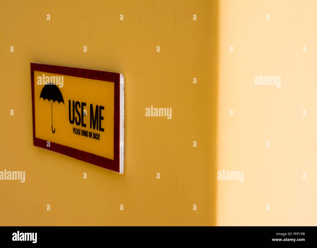 A umbrella sign saying use me against a yellow background Stock Photo ...