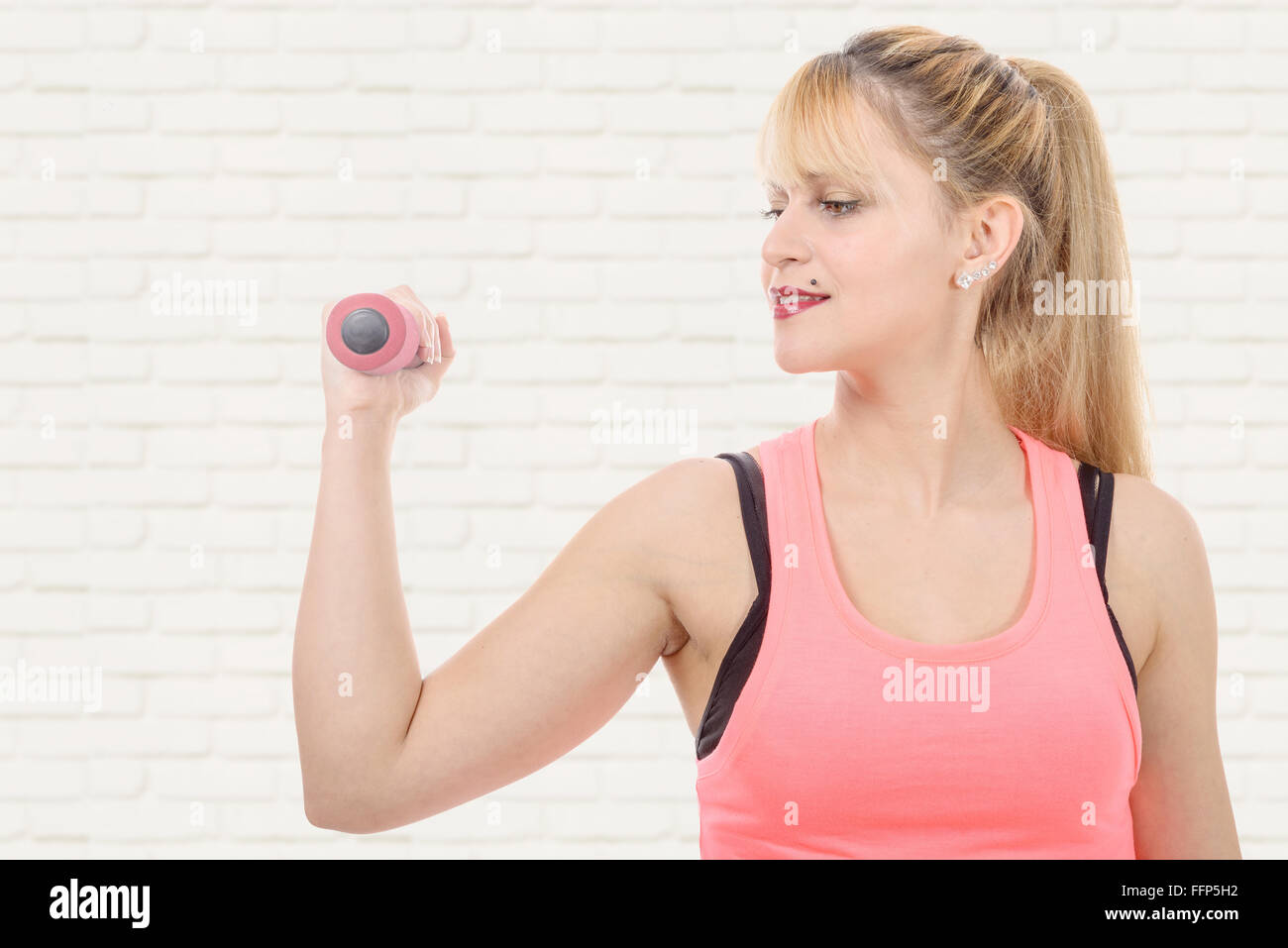 a portrait of pretty sporty girl holding weight Stock Photo - Alamy