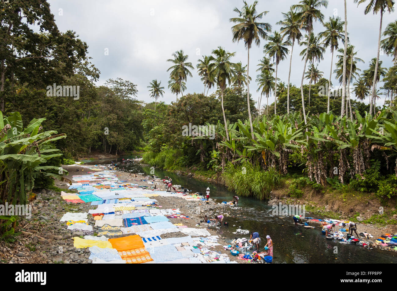 African women washing clothes on a river. Washed clothes are lied down ...