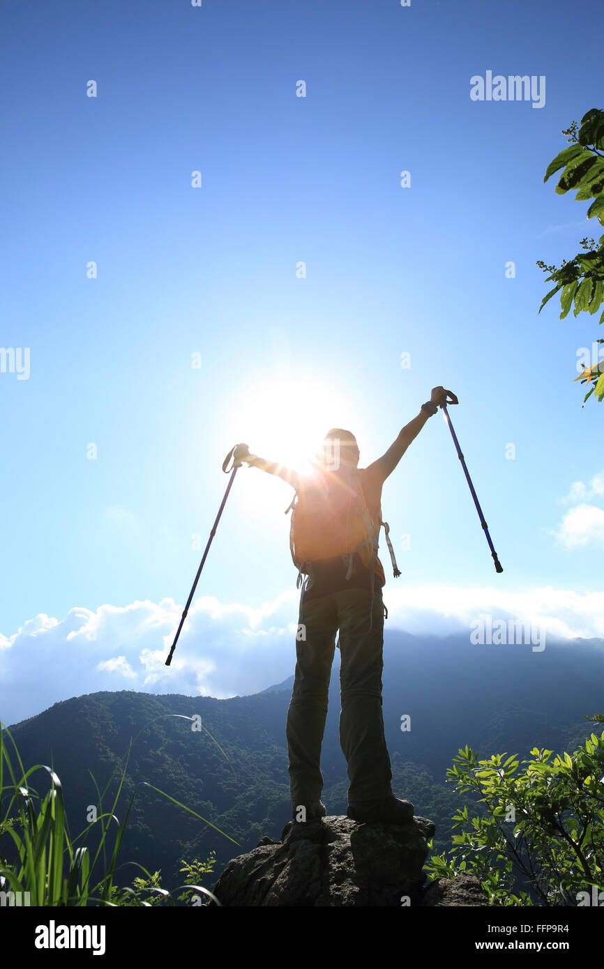 cheering young woman hiker open arms at mountain peak Stock Photo - Alamy