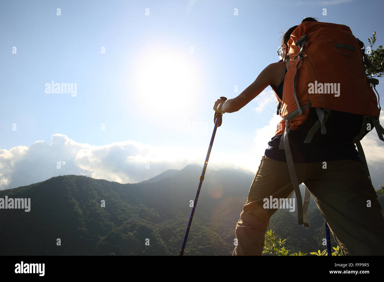 young woman backpacker climbing to mountain peak Stock Photo - Alamy