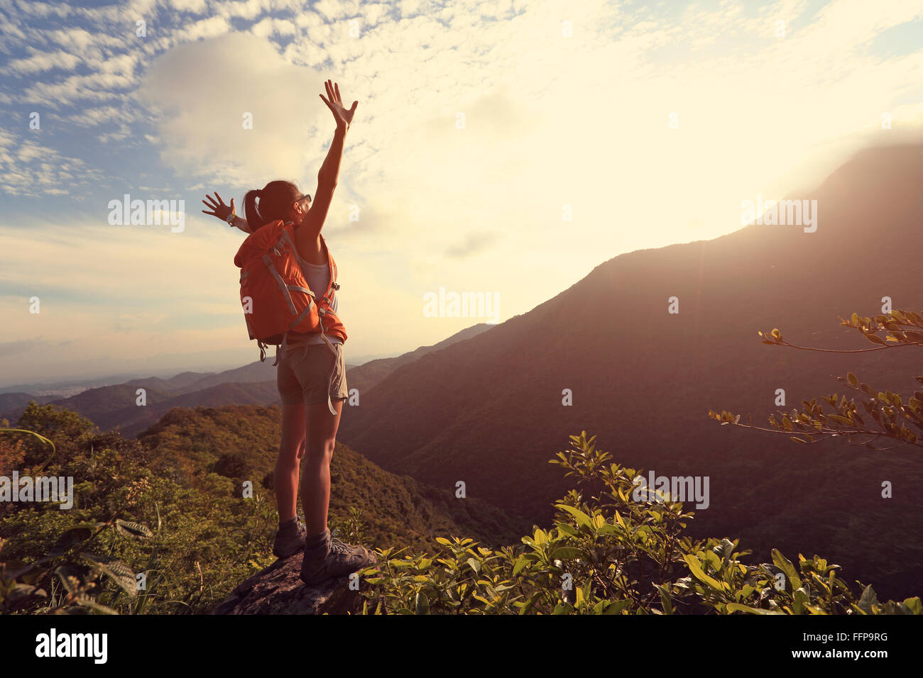 cheering young woman hiker open arms at sunrise mountain peak Stock ...