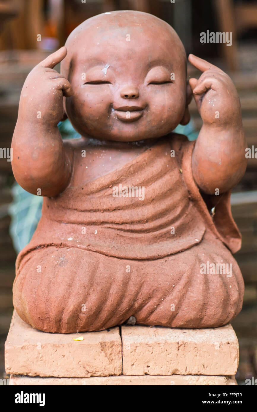 smiling buddhist novice made of clay, Thai style Stock Photo - Alamy