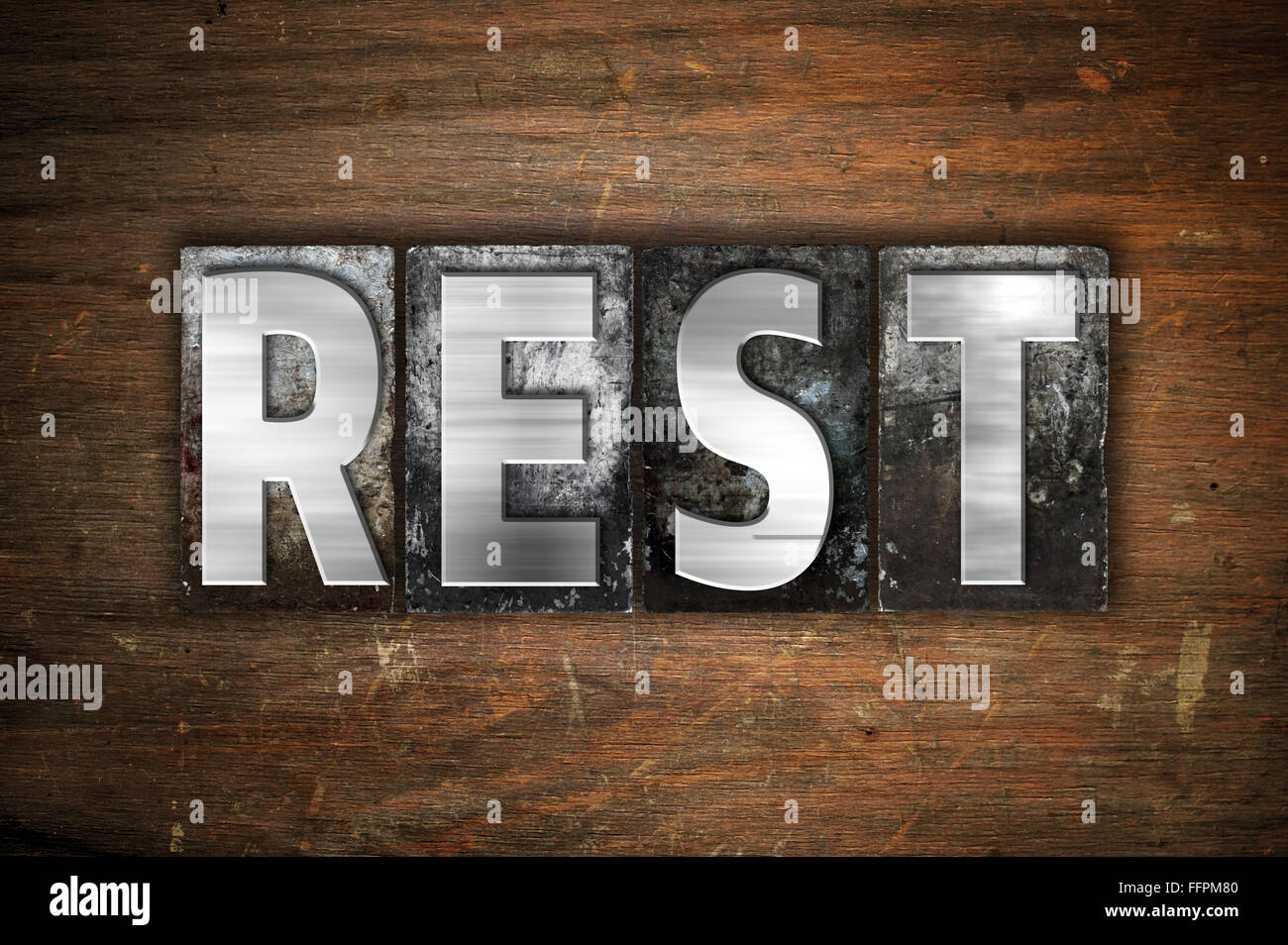The word "Rest" written in vintage metal letterpress type on an aged ...