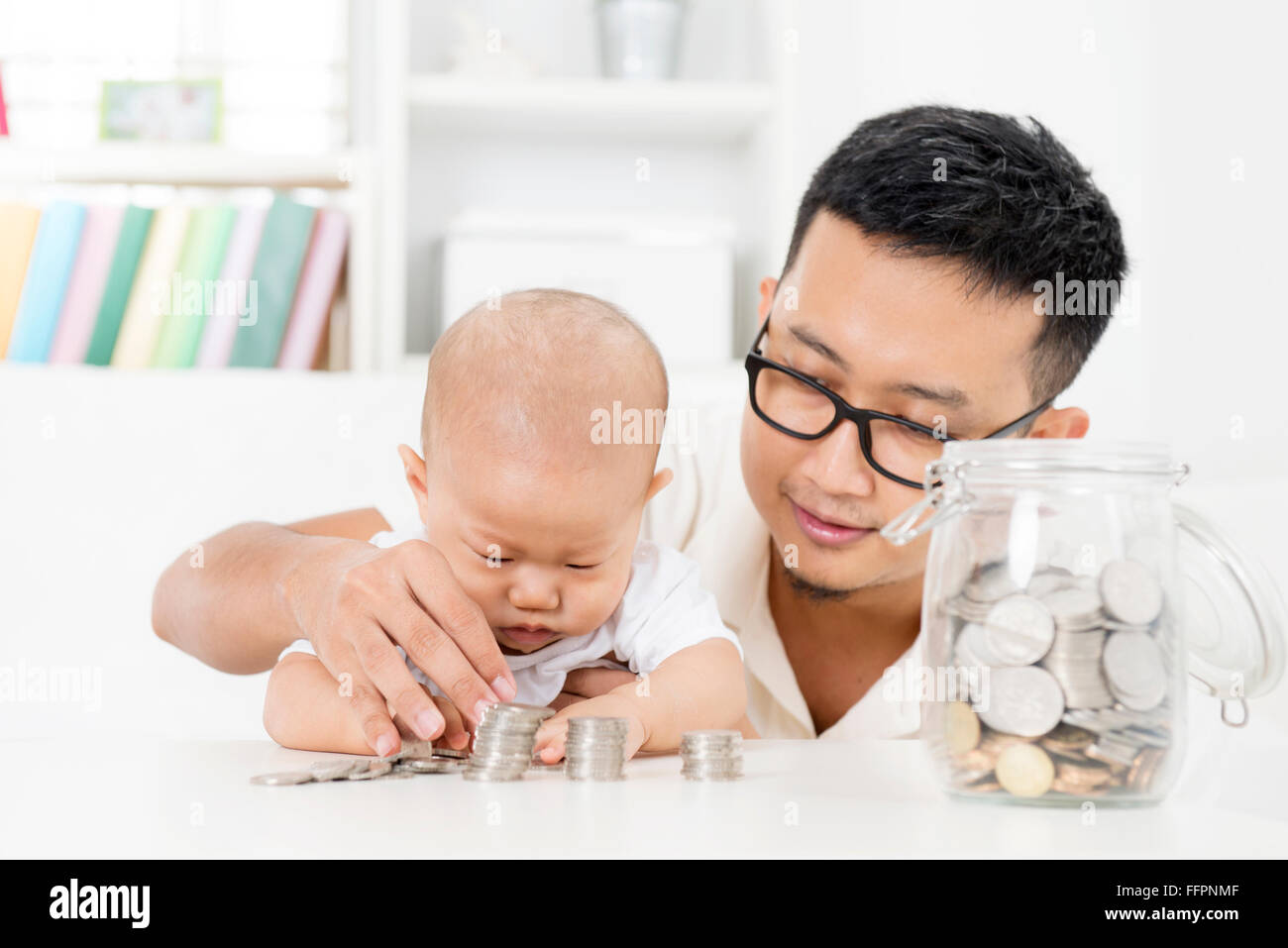Asian family lifestyle at home. Father and baby counting coins, future ...