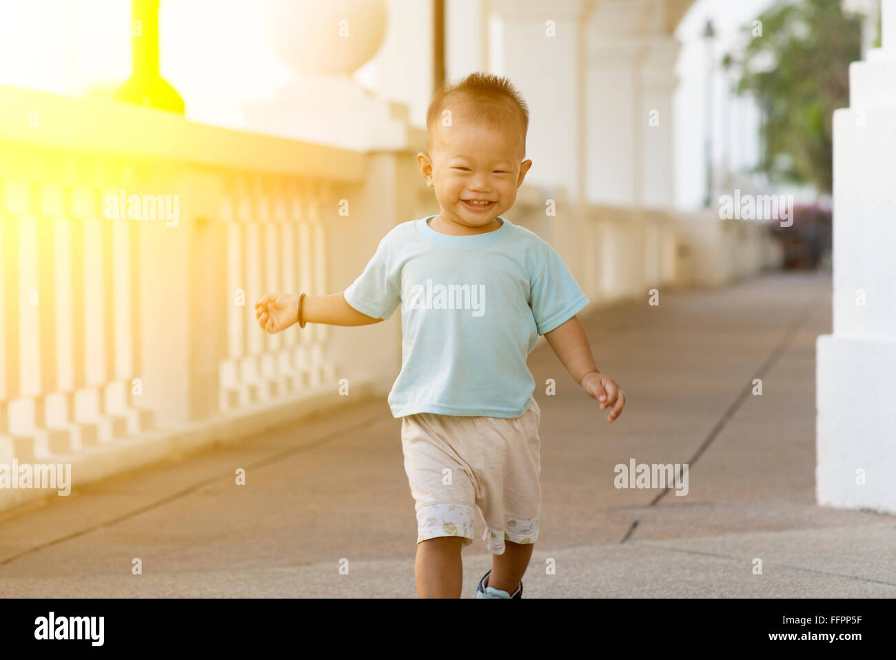 Portrait of young kid running and smiling outdoor in sunset Stock Photo ...