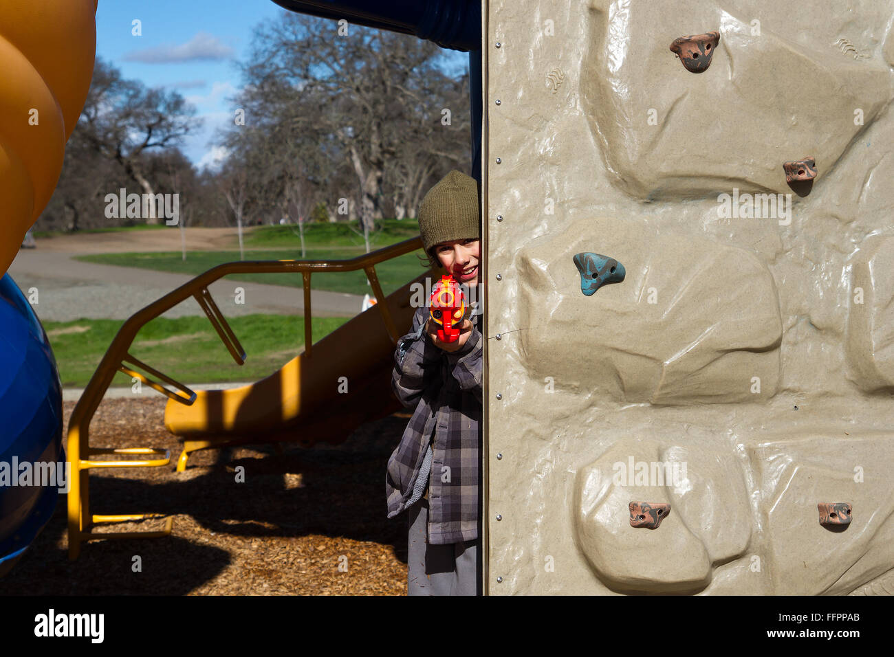Young boy playing army with a toy gun Stock Photo - Alamy