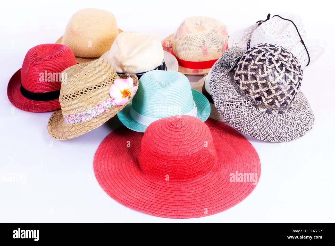 various hats of different colors grouped together on a white background ...