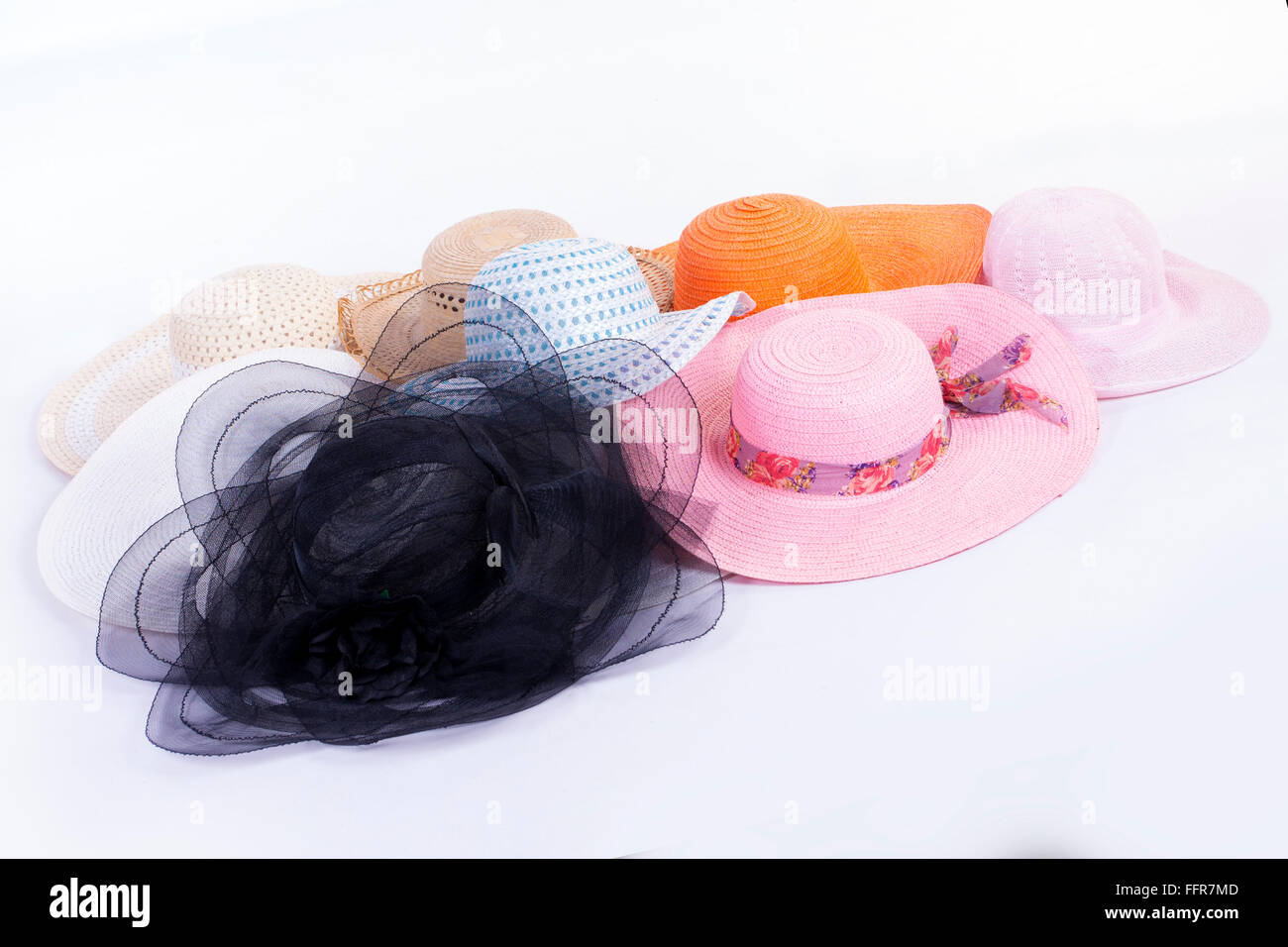 various hats of different colors grouped together on a white background ...