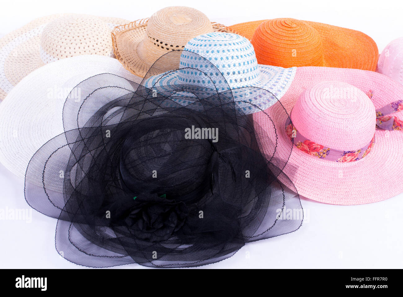 various hats of different colors grouped together on a white background ...
